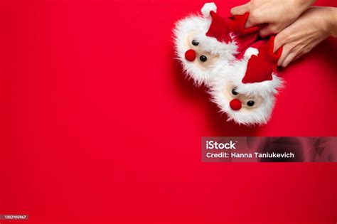 새해 텍스트 장소와 빨간색 배경에 흰색 부드러운 모피와 산타 클로스의 형태로 크리스마스 슬리퍼 재미 따뜻한 아늑하고 푹신한 어린이 신발 손에 겨울 휴가를 위한 오리지널