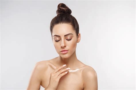 ความงามผู้หญิงใบหน้าดูแลผิวของ ภาพของหญิงสาวที่น่าสนใจใช้ครีมและถือขวด ภาพระยะใกล้ของส ภาพสต็อก