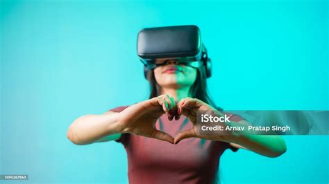 ハート型の手を持ちバーチャルリアリティヘッドセットを装着したアジアのインド人若い女性vrメガネのコンセプトスタジオポートレートを持つ女の子