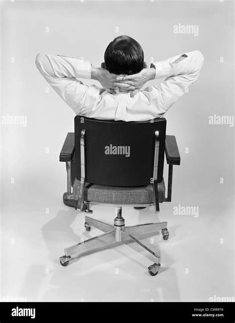 1960s Man From Behind Sitting In Office Executive Chair Hands Clasped