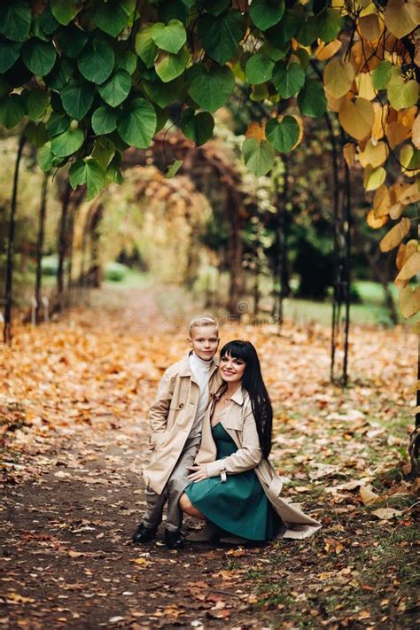 Mom And Son Are On Good Terms Walking In The Park Chatting Stylish
