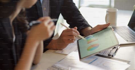 클로즈업 사업가가 디지털 태블릿 컴퓨터를 통해 사업가에게 비즈니스 원형 차트 보고서를 보여줍니다 사진 Unsplash의 팀워크 이미지