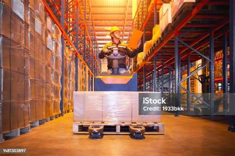 창고의 팔레트에 패키지 상자를 내리는 작업자 지게차 팔레트 잭 로더톨 선반 보관 창고 공급망 선적 상품 유통 용품 창고 물류