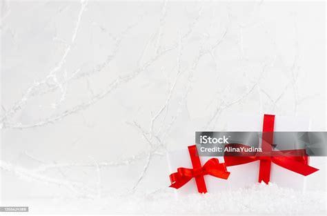 붉은 새틴 리본과 활 복사 공간과 눈과 축제 선물 상자와 반짝 흰색 장식 겨울 서리가 내린 숲 메리 크리스마스와 새해 배경 눈