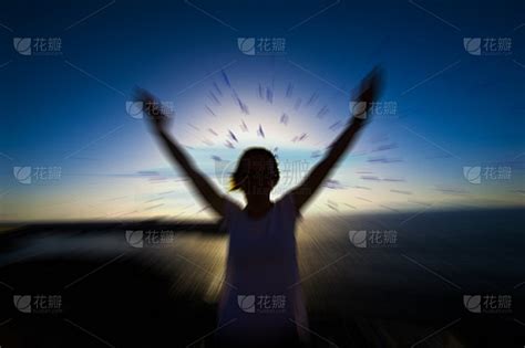 年轻的女孩向太阳张开喜悦和灵感的双手