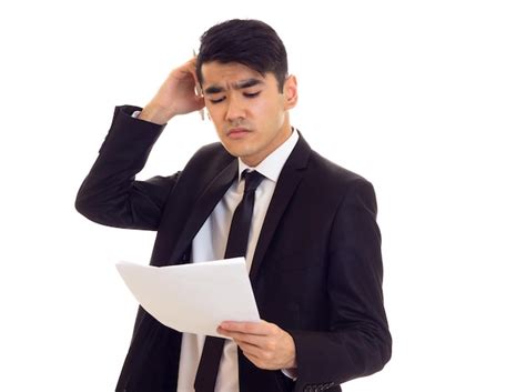 Приятный молодой человек с черными волосами в белой рубашке и черном костюме с черным галстуком