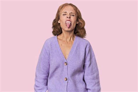 Premium Photo Redhead Midaged Caucasian Woman In Studio Funny And Friendly Sticking Out Tongue