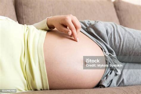 소파에 임신 한 여자와 집에서 그녀의 배를 만지고 임신 기대 개념 25 29세에 대한 스톡 사진 및 기타 이미지 25 29세