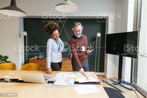 사무실의 팀워크는 창업 투자 계획을 개발하는 다양한 사업가들입니다 사무실에서 일하는 수석 고문 및 젊은 다인종 직원 25 29