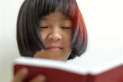 집에서 책을 읽는 아시아 아이 소녀 여성 귀여운 아이는 젊은 성인 소설을 읽기에 집중합니다 아시아 학생들은 시험을 위해 교과서를 공부합니다 세계 도서의 날과 교육 개념