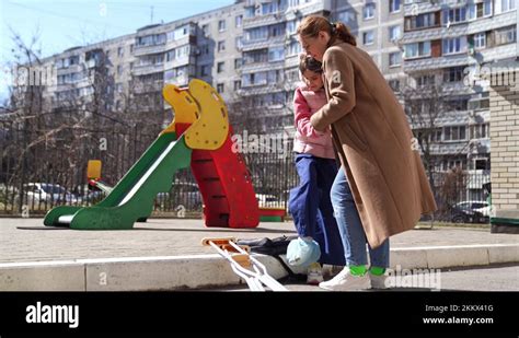 Mom Helps Her Daughter With A Broken Leg To Stand On Crutches In The