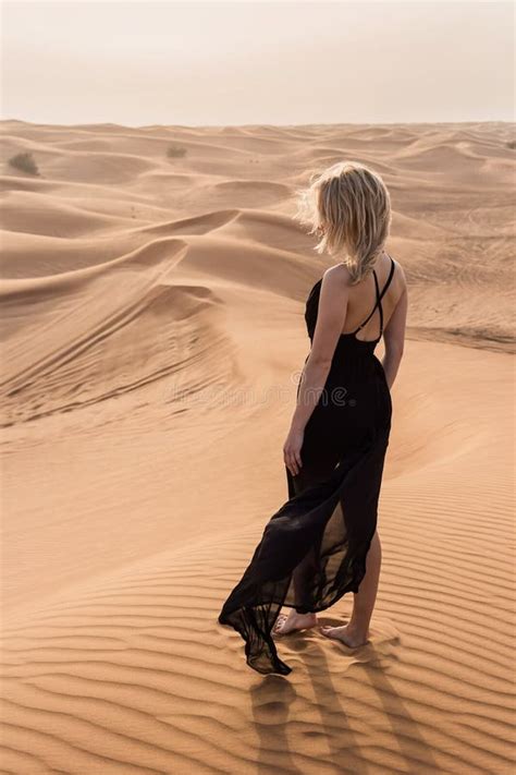 Blonde Woman In Black Dress Stands On Dune In Stock Photo Image Of Footprints Hill
