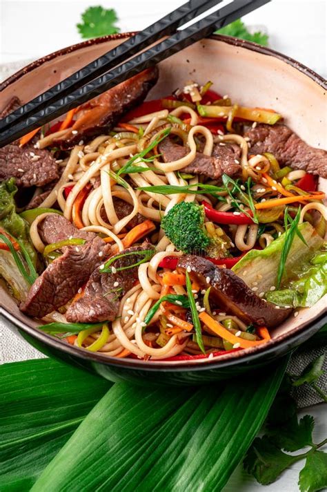 Udon Stir Fry Noodles With Beef Meat And Vegetables In A Plate On White