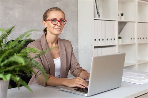 Smiling Office Worker Sits In Chair Behind Laptop Stock Image Image
