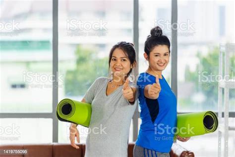 요가와 운동 후 요가 매트를 들고 웃고있는 성인과 젊은 여성이 엄지 손가락을 위로 보여줍니다 35 39세에 대한 스톡 사진 및