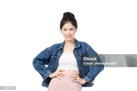 하얀 티셔츠를 입은 아름다운 아시아 여성 모델의 초상화로 데님 재킷을 입고 서서 흰색 배경에 고립 된 카메라를 보면서 포즈를