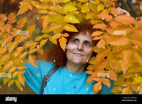 Portrait Of A Pretty Curly Haired Redhead Woman In A Colorful Autumn