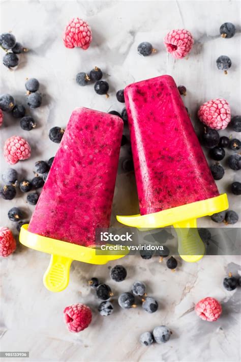 베리 나무 딸기와 건포도 특수 금형의 도움으로 만든 막대기에 아이스크림 회색 테이블에 냉동된 딸기 들 평면도 평면 위치 건강한 식생활에 대한 스톡 사진 및 기타 이미지