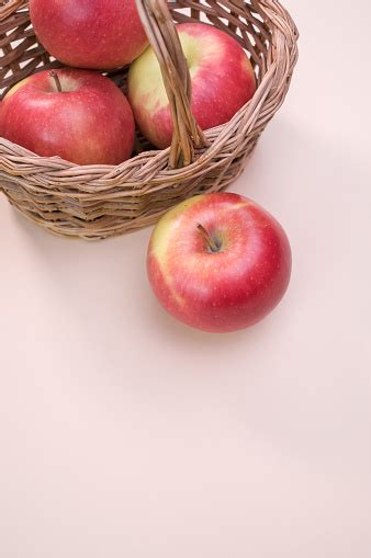 복사 공간이 있는 밝은 분홍색 배경에 격리된 고리 버들 바구니에 빨간 사과의 수직 샷 0명에 대한 스톡 사진 및 기타 이미지