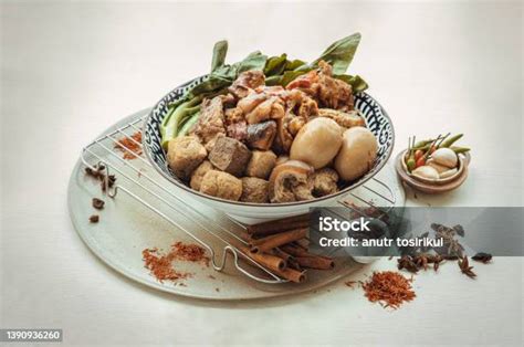 조림 돼지 고기 다리 삶은 달걀 두부와 케일을 세라믹 그릇에 넣고 흰 배경에 마늘과 기니 고추를 곁들였습니다 0명에 대한 스톡