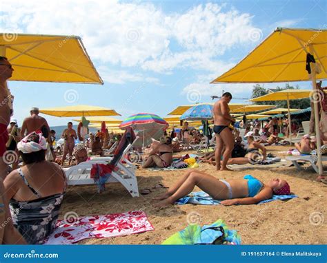 City Beach People Are Sunbathing Relaxing Under Umbrellas On The Sand