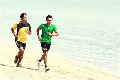 Hombre Que Corre En La Playa Imagen De Archivo Imagen De Amigo Cubo