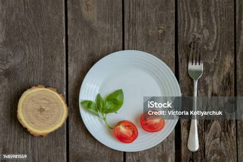 부엌의 오래된 테이블에 바질과 토마토 장식이 있는 깨끗한 빈 접시와 포크 스탠드 0명에 대한 스톡 사진 및 기타 이미지 0명