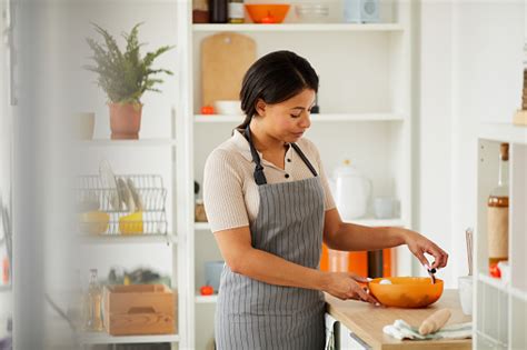 부엌 카운터에 서서 플라스틱 그릇에 재료를 혼합에 앞치마에 젊은 흑인 여성을 주의 하는 내용 가정 생활에 대한 스톡 사진 및 기타 이미지 Istock
