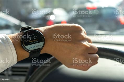 교통 체증과 자동차 비즈니스 남자 보고 Smartwatch 가죽 시계 왼쪽에 검은 색 원 앞 의제 주간 회의 일정 알림 때