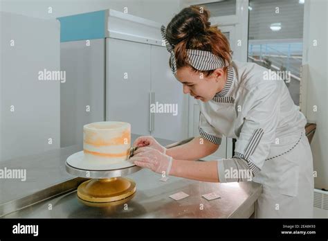 Female Confectioner Decorating Birthday Cake In The Confectionery