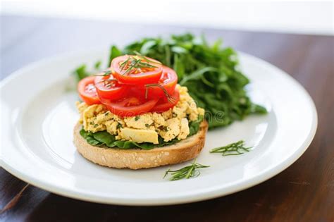 Scrambled Tofu On A Bagel With Arugula And Sliced Tomato Stock