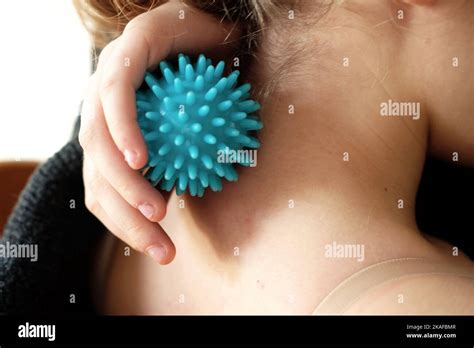 Girl Messaging Her Back And Neck With A Message Ball With Spikes Stock