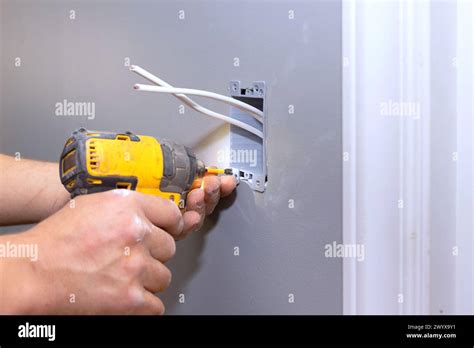 In Course Of Renovating Residence Professional Electrician Connects An Electric Socket To Wall
