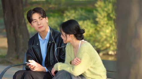 공원 벤치에서 이어폰을 나누는 커플 드롭샷 스톡 영상 무료 다운로드