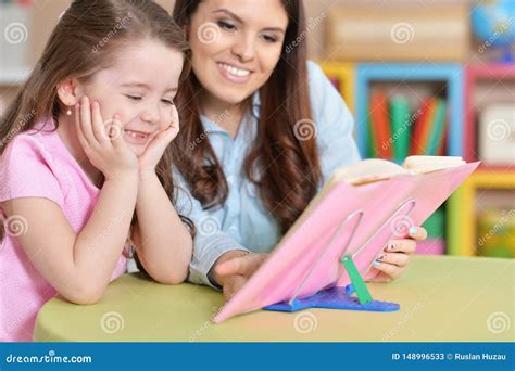 Mother And Daughter Doing Homework Together In Room Stock Image Image