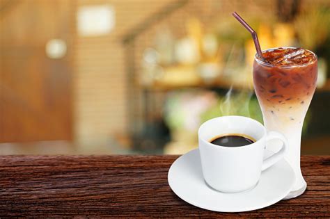 인테리어 커피 숍의 흐리게에 나무 테이블에 커피 컵 커피와 비즈니스 시간 커피 컬러 갈색 배경 제품 디스플레이 텍스트에 대 한 여유 공간 산업 음식과 음료 배경 개념입니다