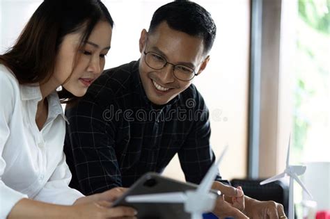 Sustainability Engineers Discussing Innovative Designs In A Modern