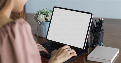 나무 테이블에 모형 스크린이 있는 디지털 태블릿으로 작업하는 여성의 모습을 닫습니다 사진 Unsplash의 태국 이미지