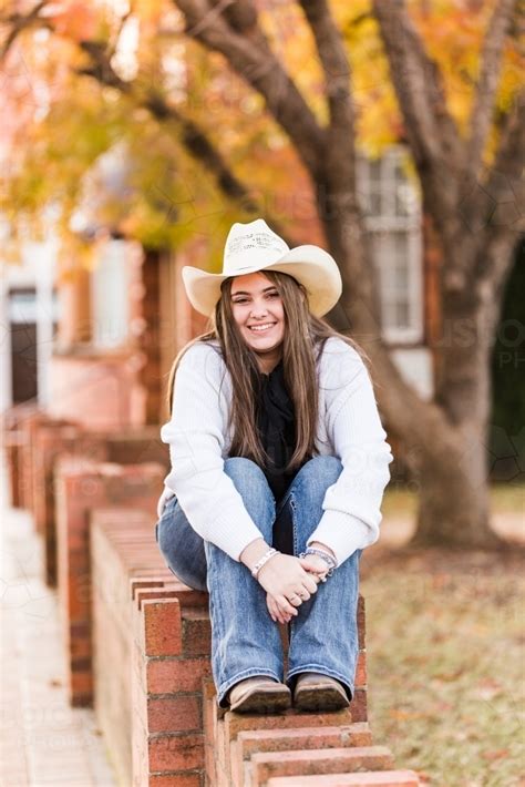 Image Of Girl Smiling Sitting On Brick Wall Austockphoto