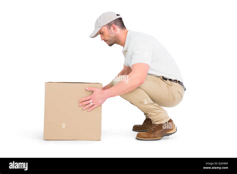 Delivery Man Crouching While Picking Cardboard Box Stock Photo Alamy