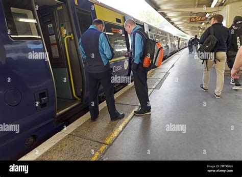 London England Uk Two Train Guards Checking Their Mobile Phones At A