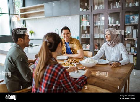 Friends Having Fun Eating Lunch Together At Home With Traditional Food