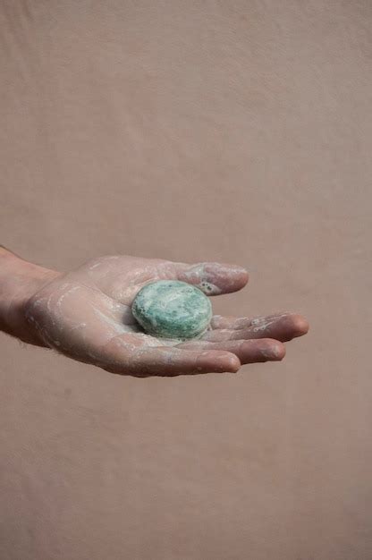 Premium Photo Wet Shampoo Or Soap Bar With Foam Holding By A Men Hand