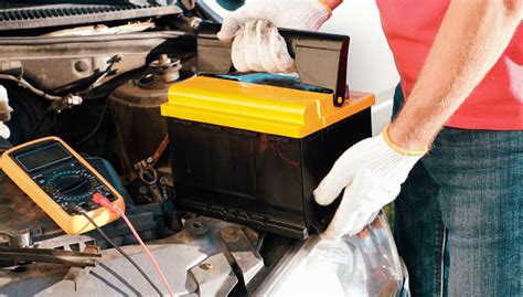 겨울 전에 자동차 유지 보수 자동차 정비사가 자동차 배터리를 교체하고 있습니다 새 배터리를 설치할 때 배터리로 손을 볼 수 있습니다 검사 보기에 대한 스톡 사진 및 기타