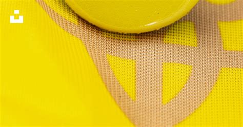 黄色と青のシャツの上に座っている青と黄色のボタンの写真 Unsplashの無料ロゴ写真