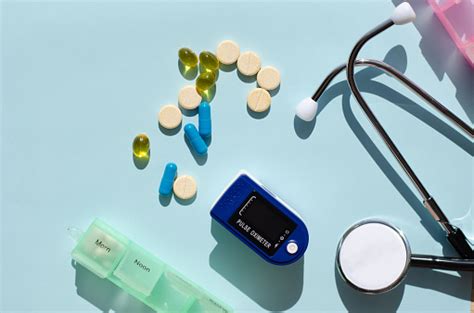 청진기가 테이블 위에 있습니다 평범한 배경에 약이있는 정제와 캡슐 맥박계 맥박 산소 측정기 의료 기기 음운내시경 살균 패치 톤계