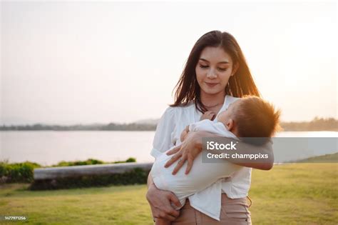 어머니 육아와 신생아 출산 생활 엄마와 아기는 공원 일몰에서 놀고 가족은 함께 즐거운 시간을 보내고 있습니다 육아 출산 개념
