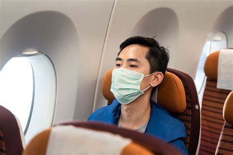 아시아 여행자 사업가가 공항에 있는 비행기의 창문에서 보이는 보호 얼굴 마스크를 착용하고 좌석에 앉아 있는 모습 유비 바이러스