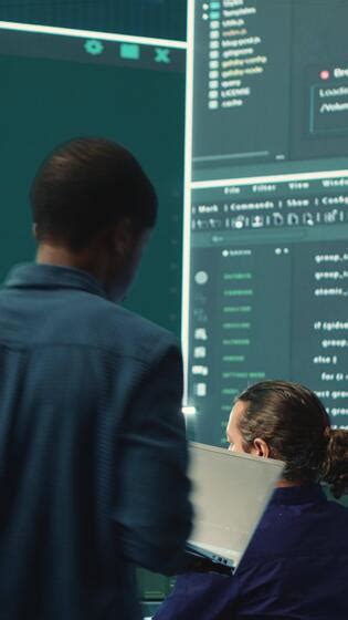 Vertical Governmental Hackers Analyzing Cyber Threats On Big Screens Managing Important