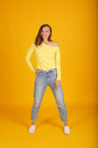 Premium Photo A Beautiful Young Girl In A Yellow Jacket And Jeans